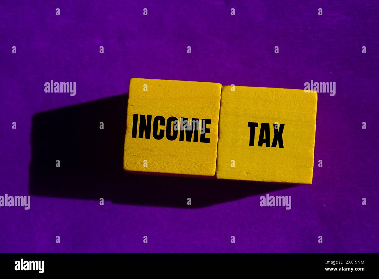 Income tax message written on yellow wooden cubes with purple ...