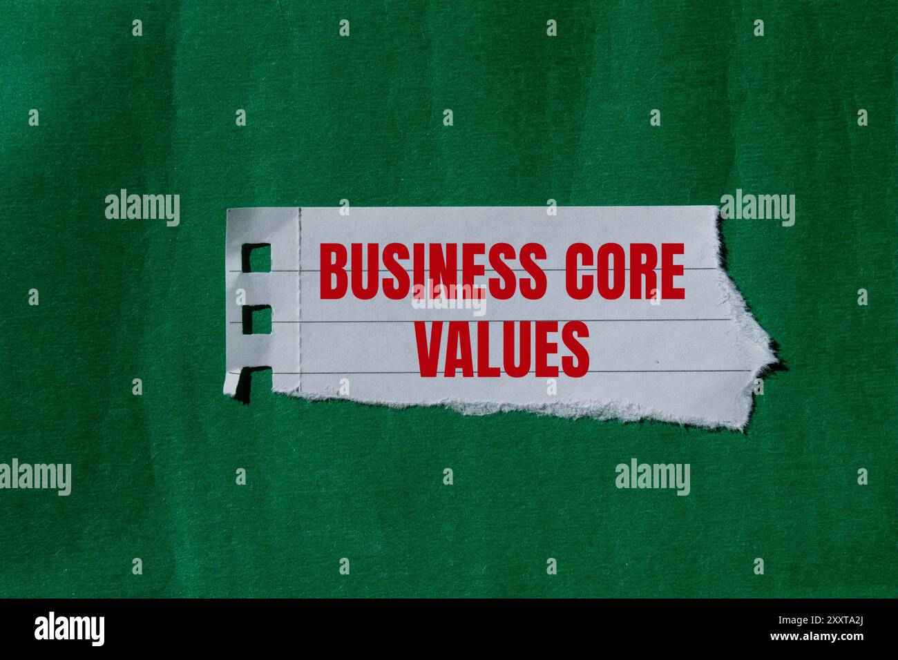 Business core values message written on ripped paper piece with green ...