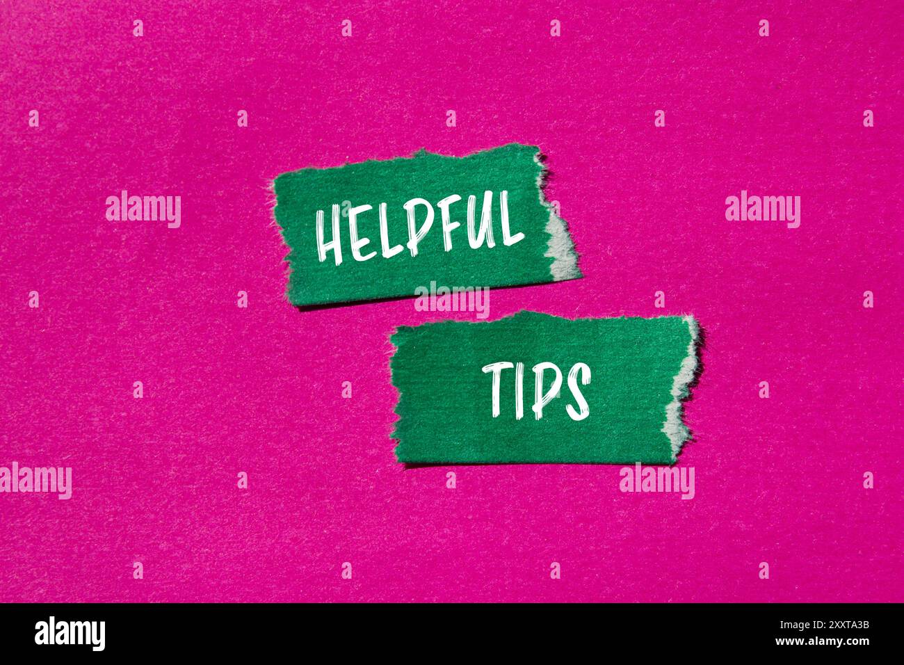 Helpful tips message written on ripped torn green paper pieces with pink background. Conceptual ...