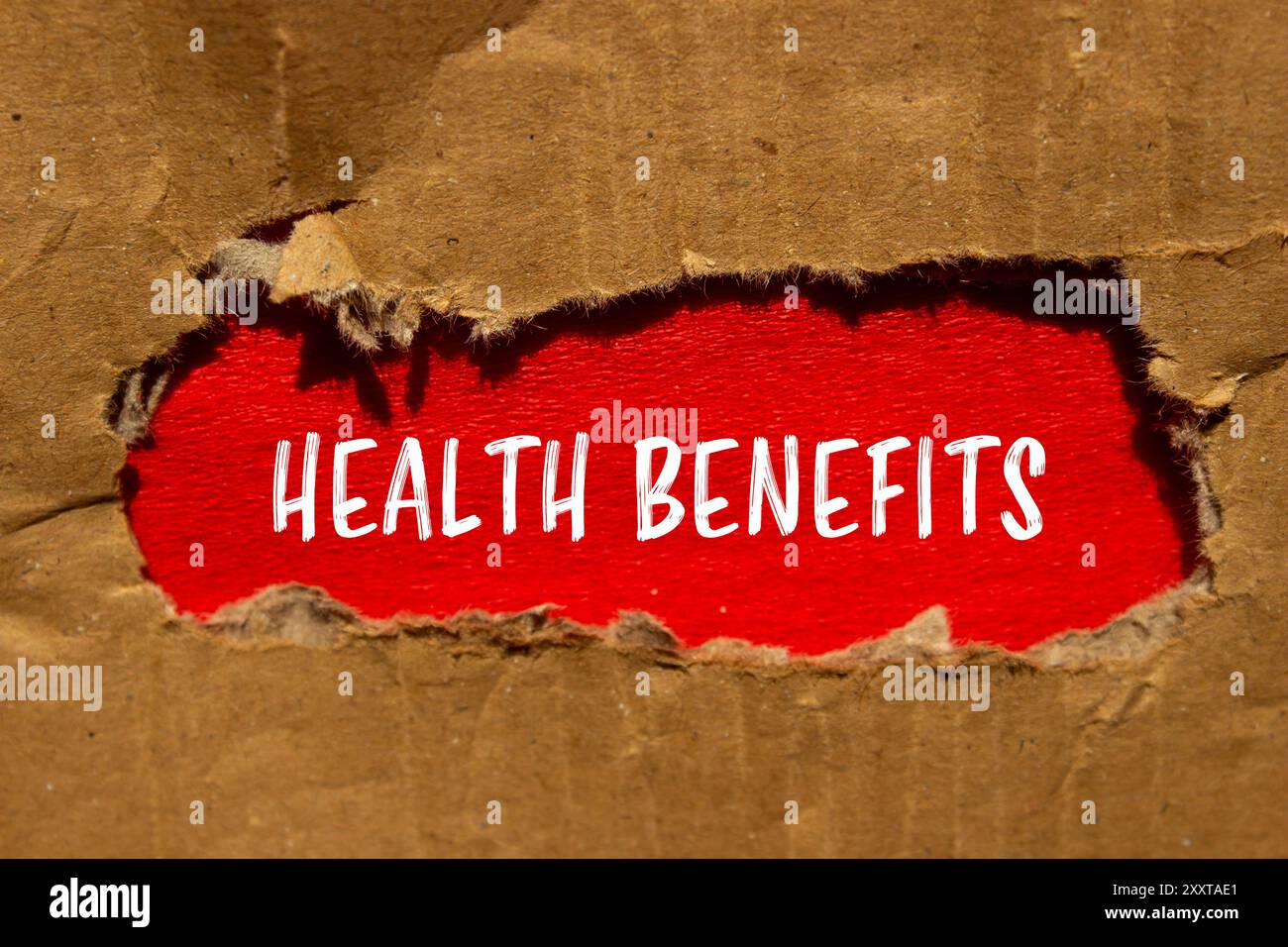 Health benefits message written on ripped torn cardboard paper with red background. Conceptual ...