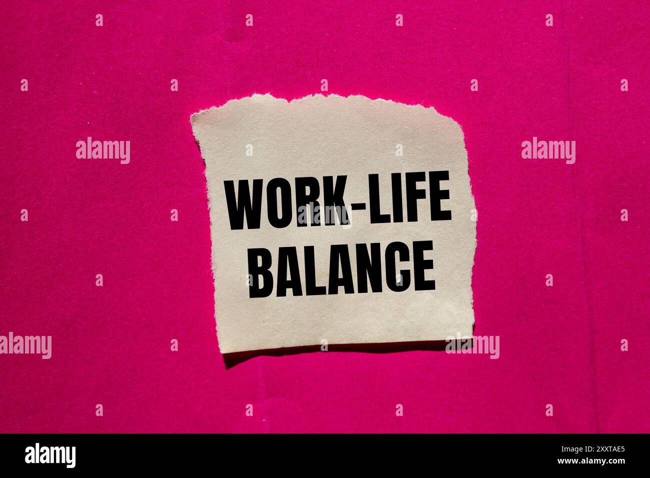 Work life balance message written on ripped torn paper piece with pink ...