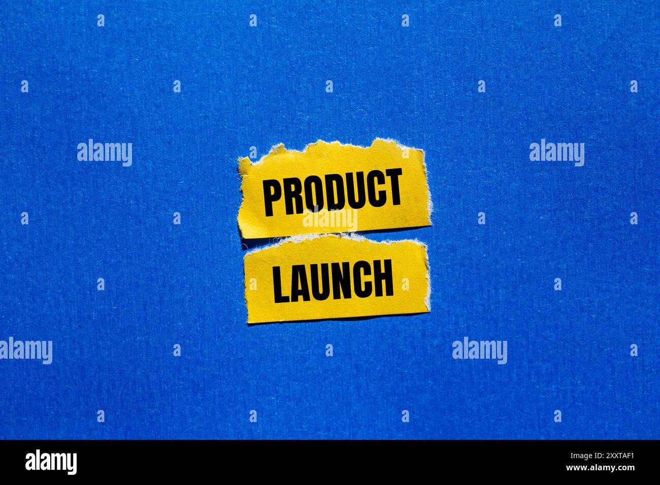 Product launch message written on ripped torn yellow paper pieces with ...