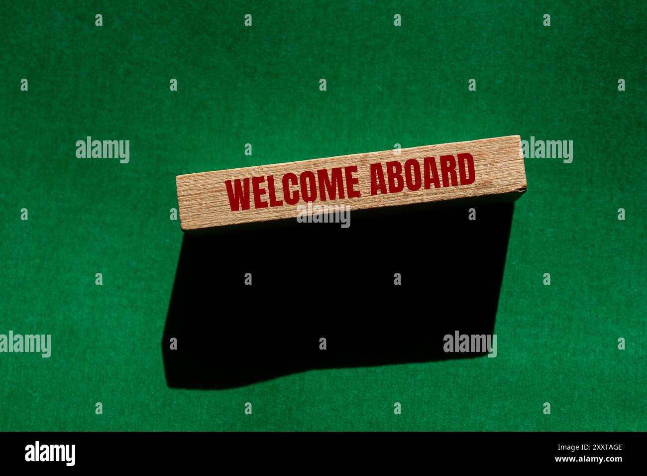 Welcome aboard message written on wooden blocks with green background ...