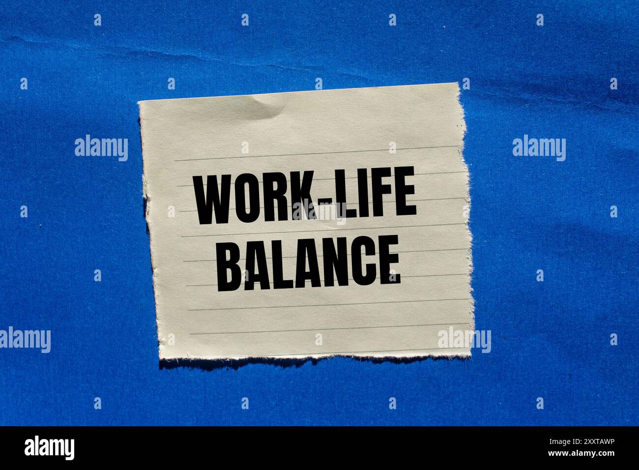 Work life balance message written on ripped torn paper piece on blue ...