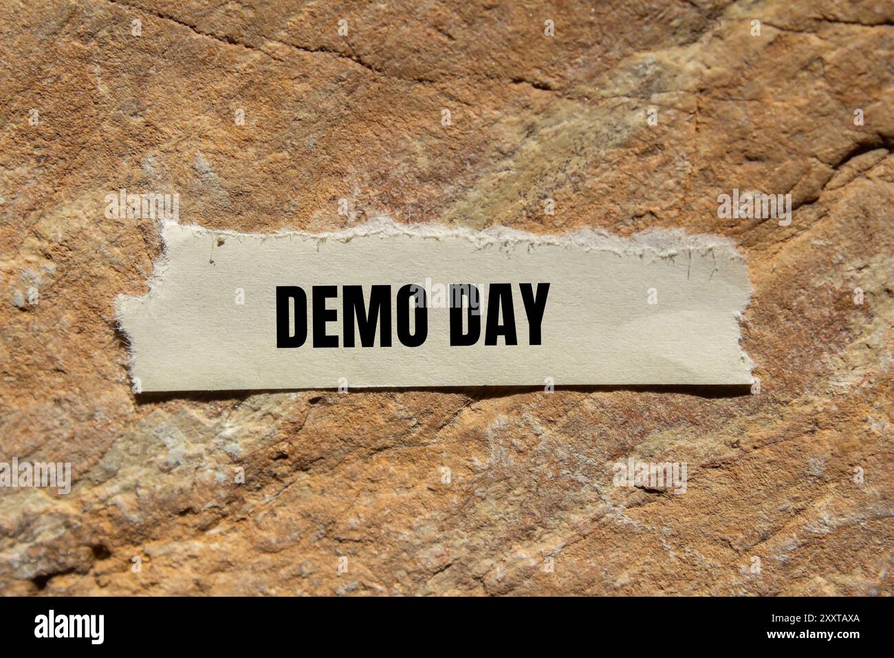 Demo day message written on ripped torn paper piece on stone background ...