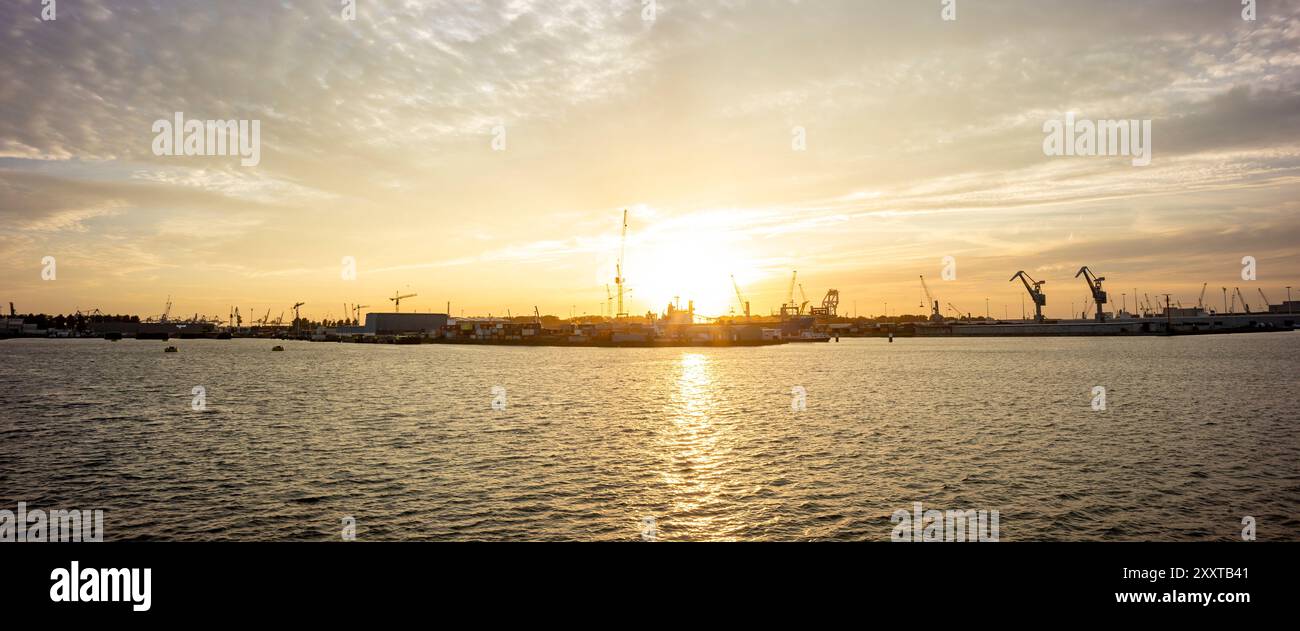 Dynamic silhouette of a quay with machinery in an open air shipyard ...