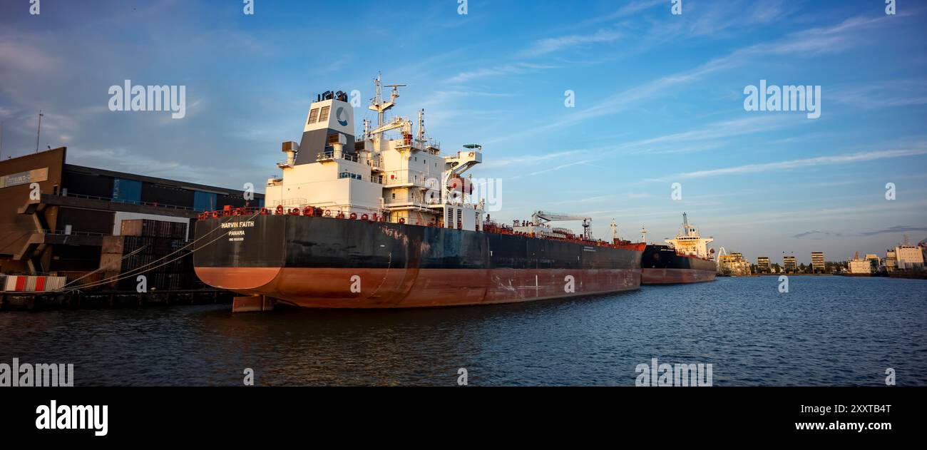 Large seafarer cargo ship vessel on quay of Rotterdam harbour against a ...