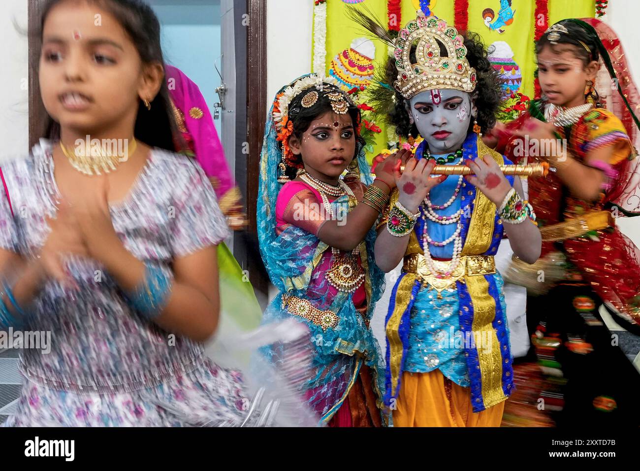 School children dressed as Lord Krishna, second right and his consort ...