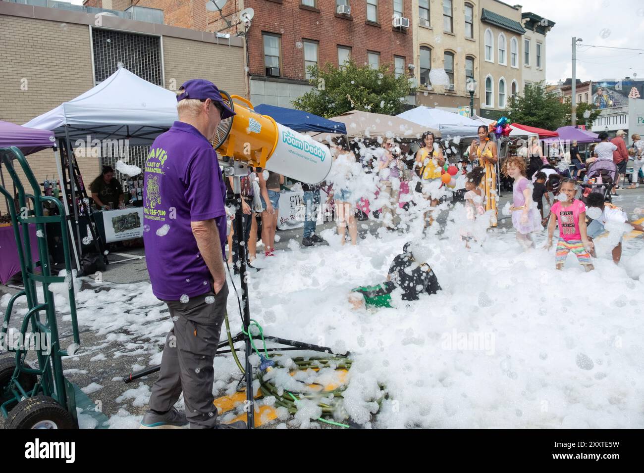 At the annual Oz Fest, a man entertains the kids by shooting foam at ...