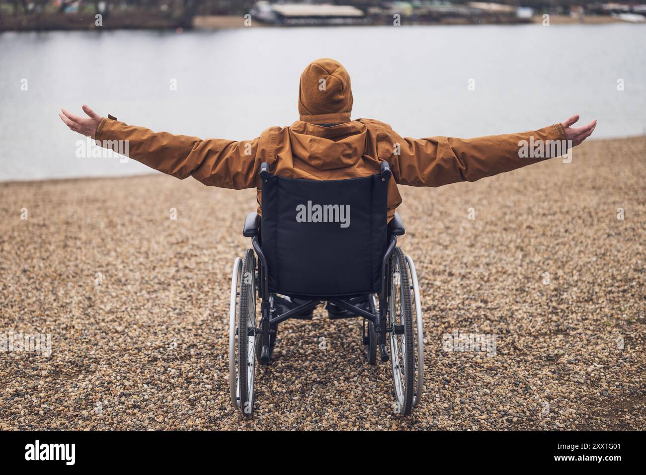 Rear view image of paraplegic handicapped man in wheelchair by the lake ...