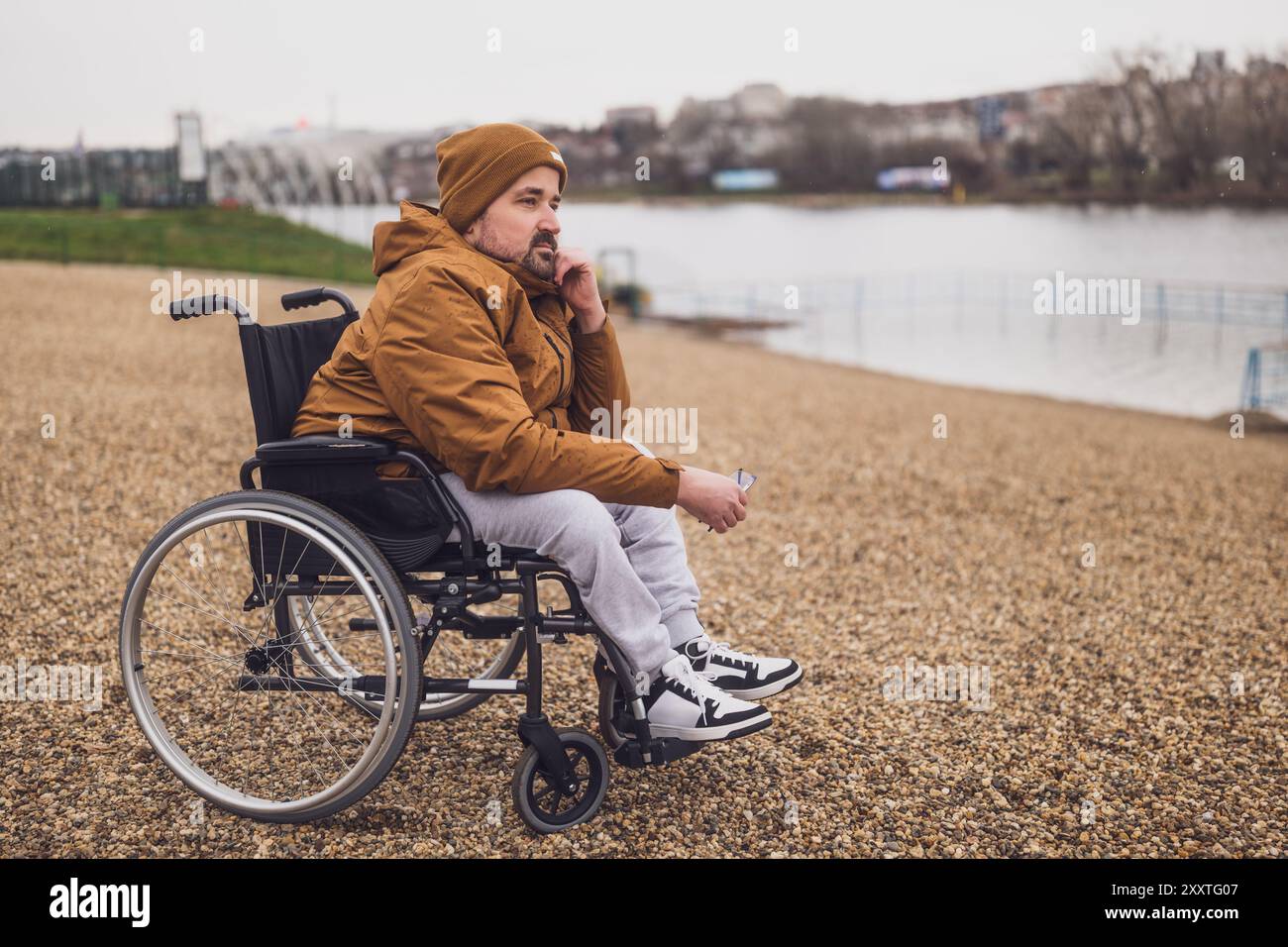 Portrait of paraplegic handicapped man in wheelchair. He is thoughtful ...
