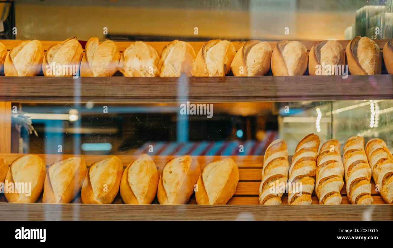 Freshly baked loaves of bread neatly arranged on wooden shelves in ...