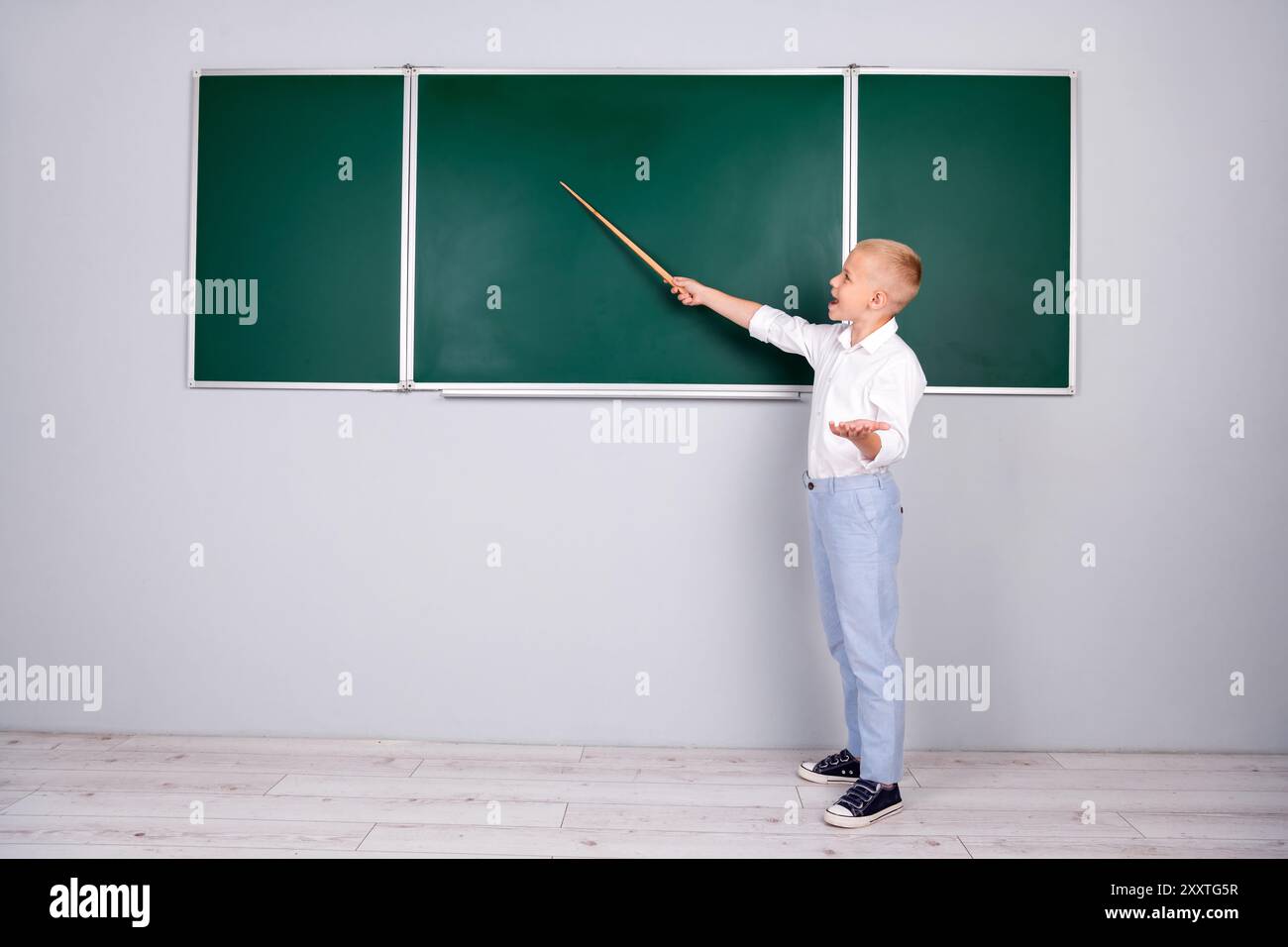 Photo of charming clever nice boy learner standing in class room ...