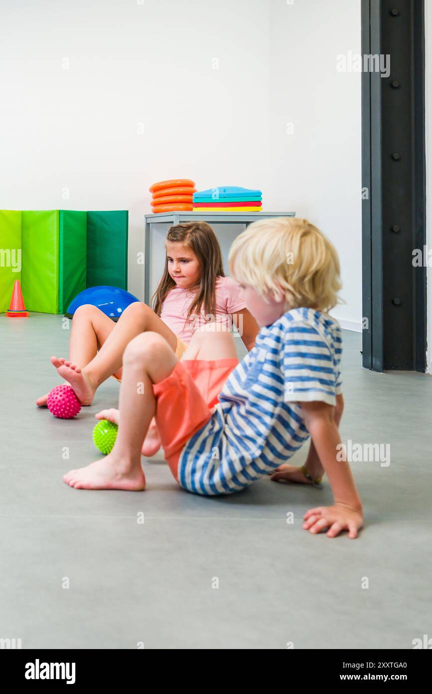Children during physical therapy session. Kids exercising barefoot with ...