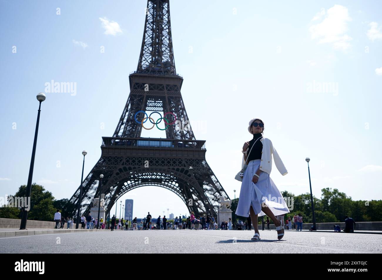 People poses for photographs in front of the Eiffel Tower with the ...