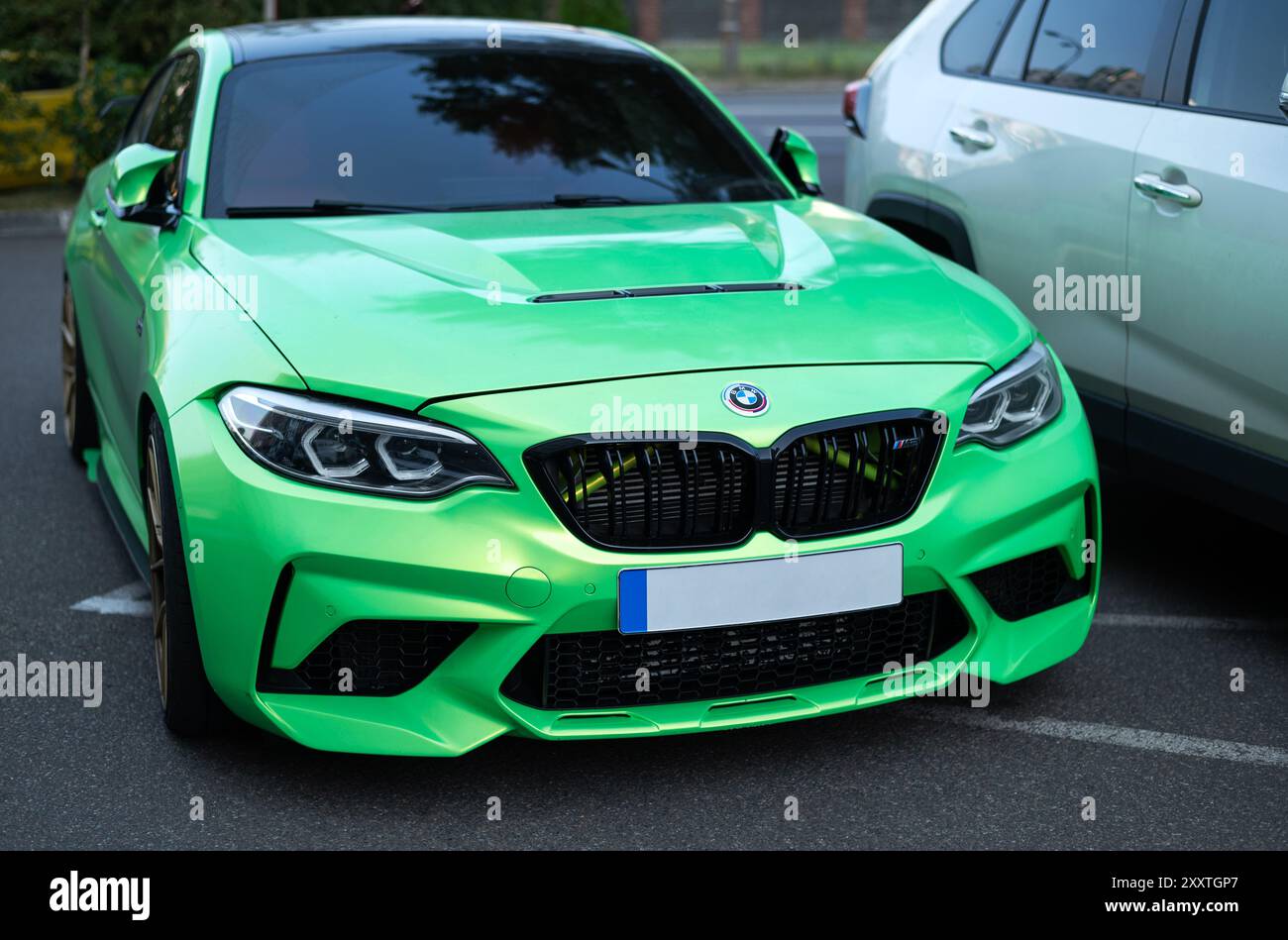 Vibrant green BMW M2 parked on street, showcasing sleek design and bold ...