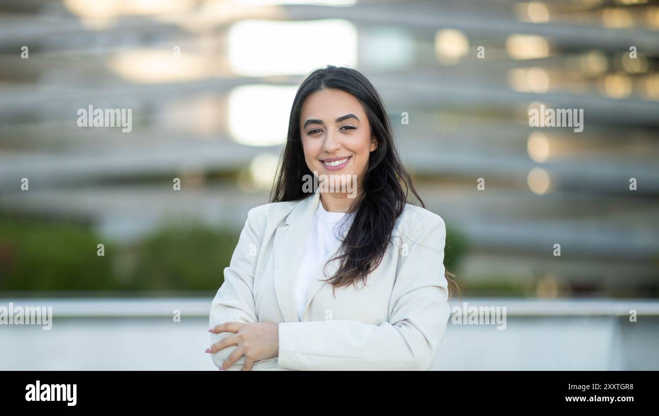 Young woman smiles confidently outdoors in urban setting during ...