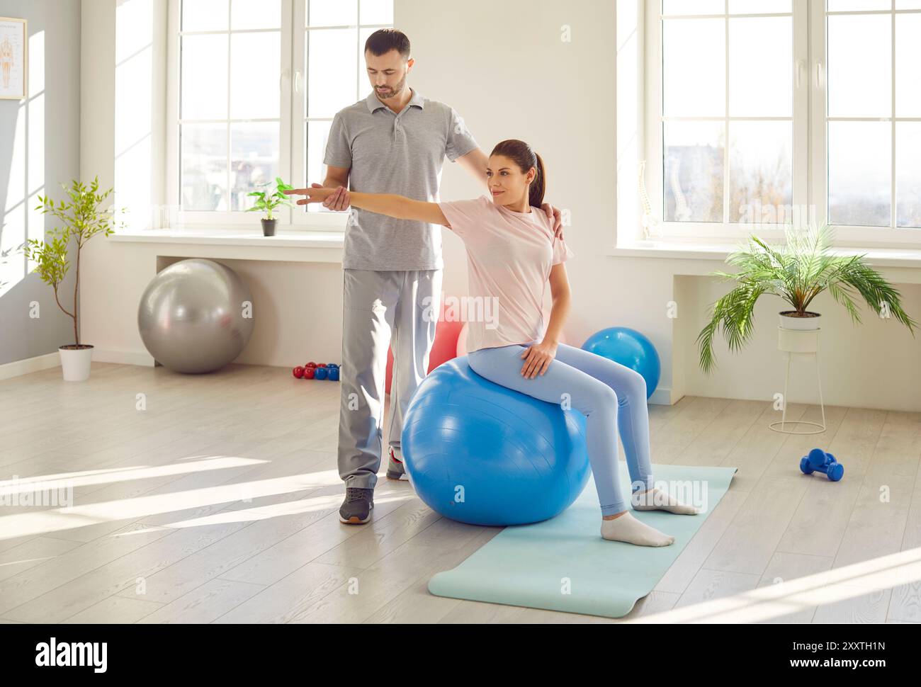 Physiotherapist helping woman patient do rehabilitation exercises for ...