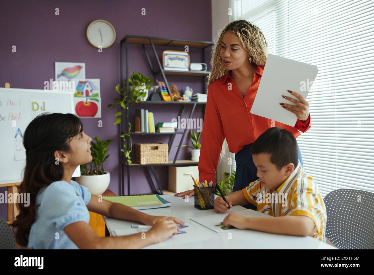 Teacher guiding students writing in hi-res stock photography and images - Alamy