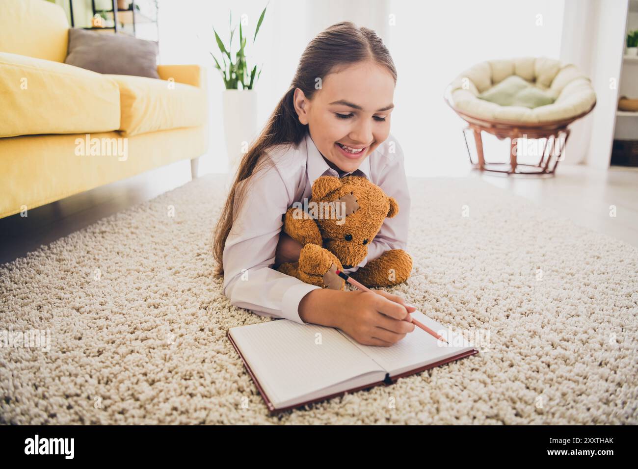 Full length photo of cute adorable teen girl lying floor write notebook ...