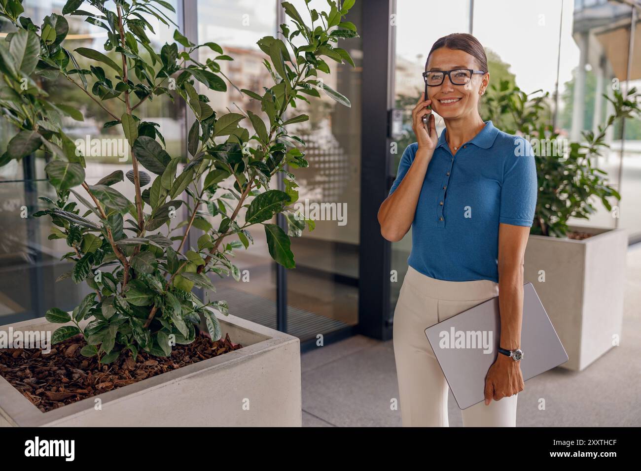 A confident professional woman in a modern office, working with her ...