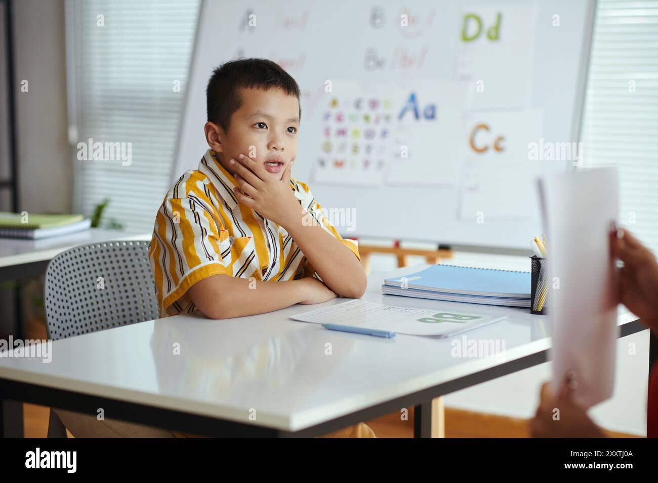 Young Boy Learning in Classroom Environment Stock Photo - Alamy