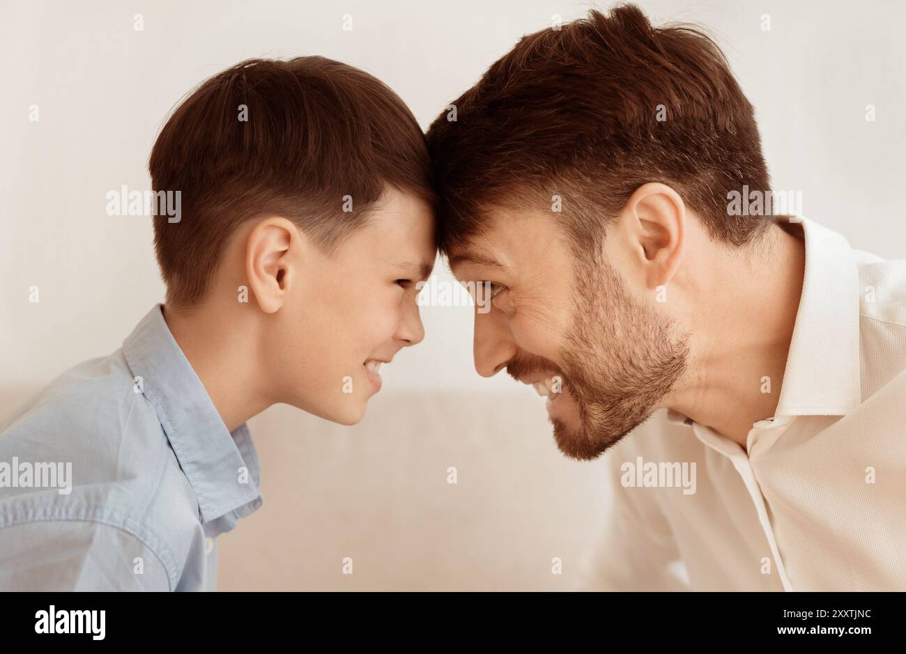 Happy Father And Son Bowing Heads Touching Foreheads, White Background ...