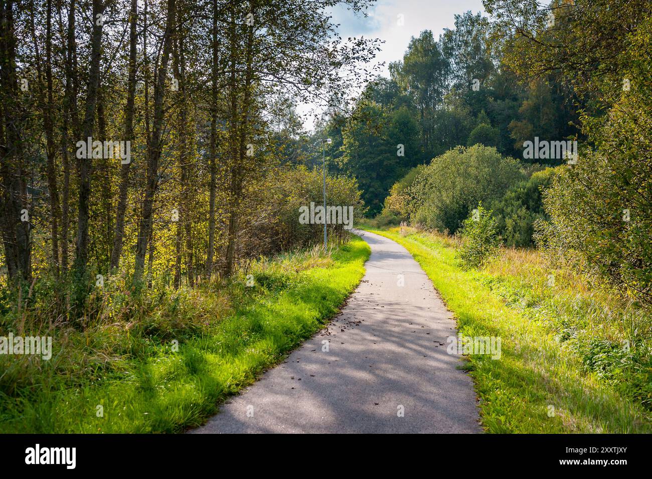A concrete asphalt paved walking trail leads a nature underground cave ...