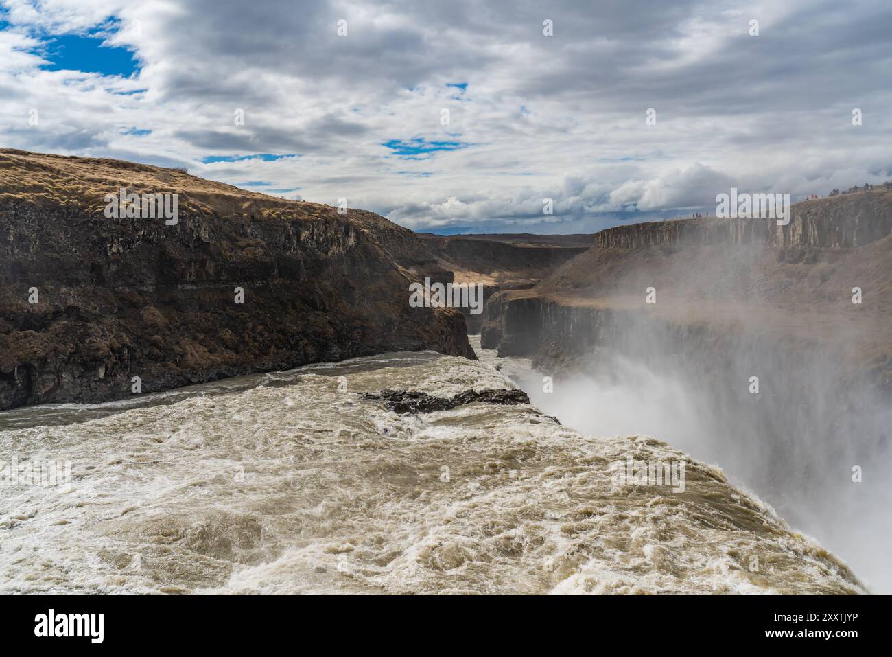 Water cascades over gullfoss waterfalls on a cloudy day in Iceland at ...