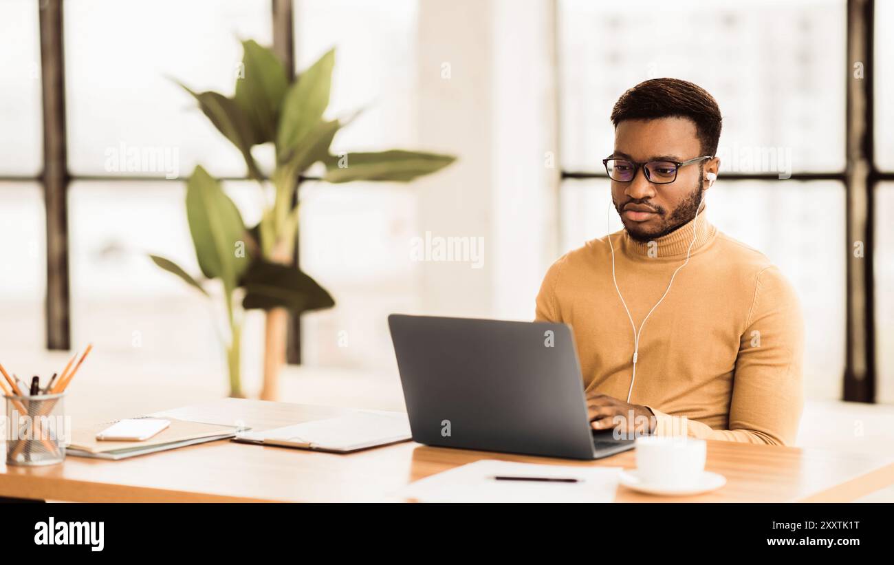 Concentrated afro guy in eyewear typing on keyboard Stock Photo - Alamy