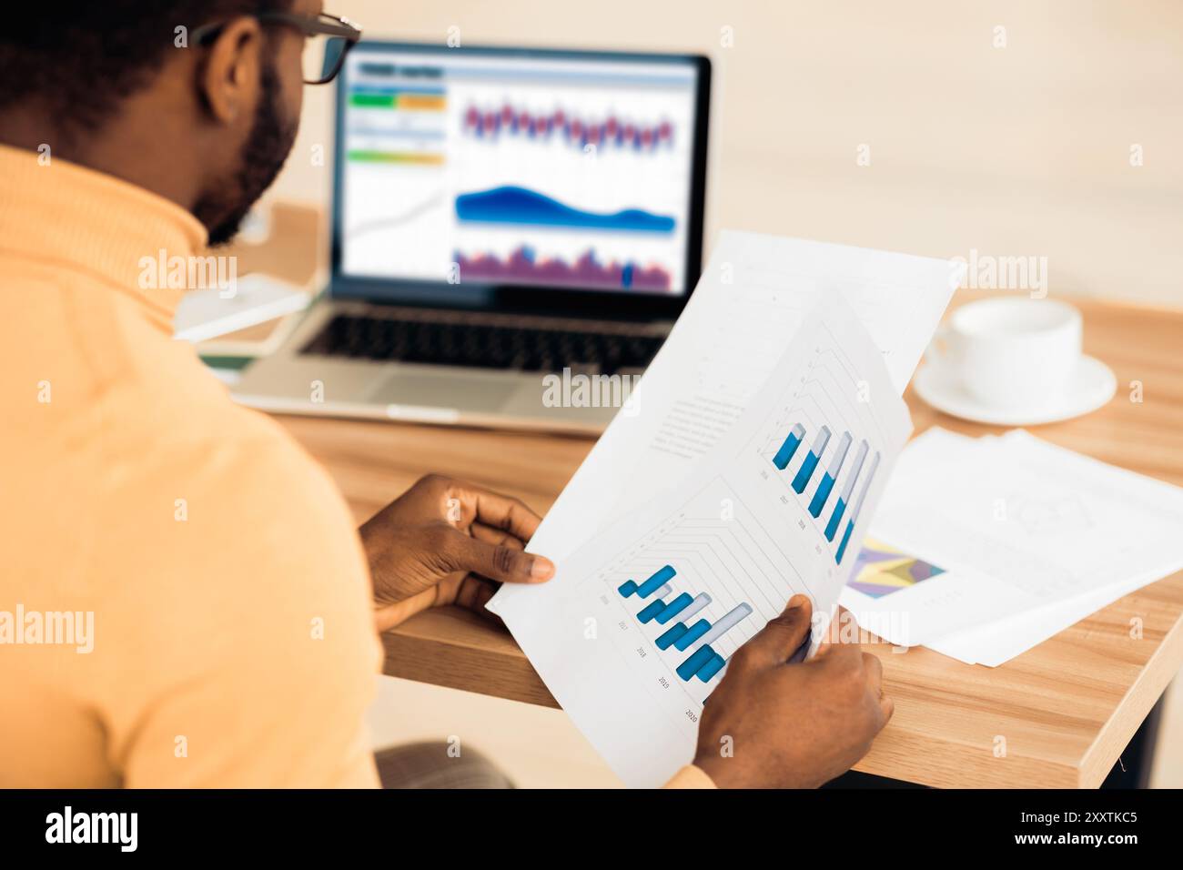Black manager working with diagrams on pc and paper Stock Photo - Alamy