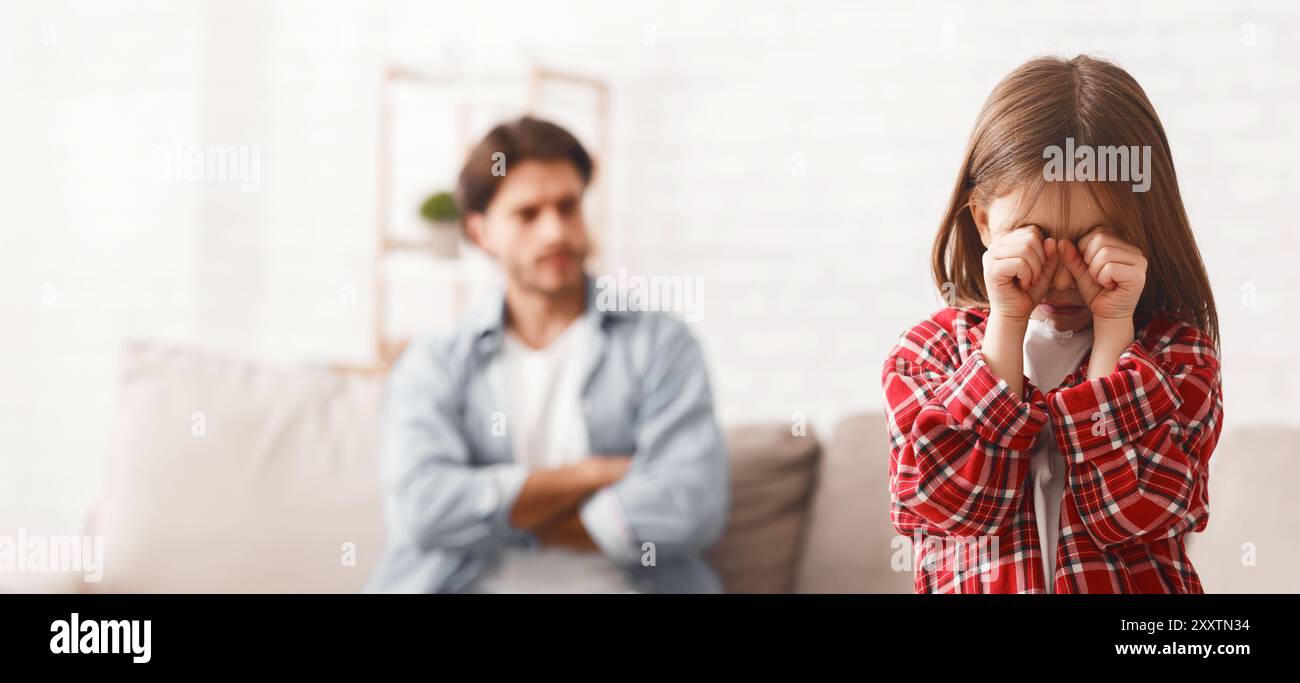 Little girl crying after quarrel wIth father, angry dad behind Stock ...