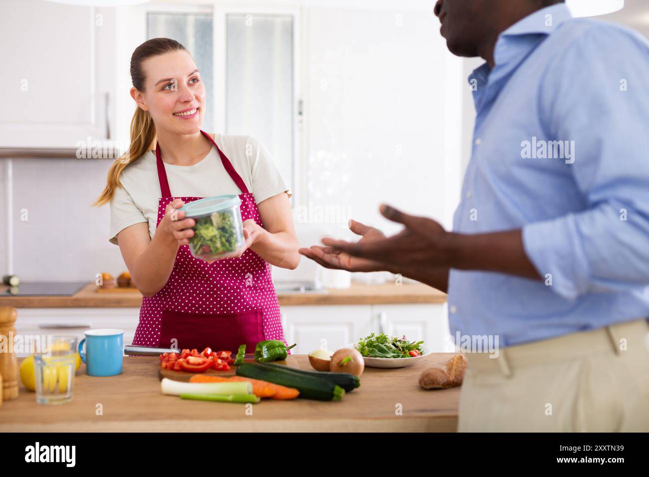 Woman giving container with food to her husband before work Stock Photo ...