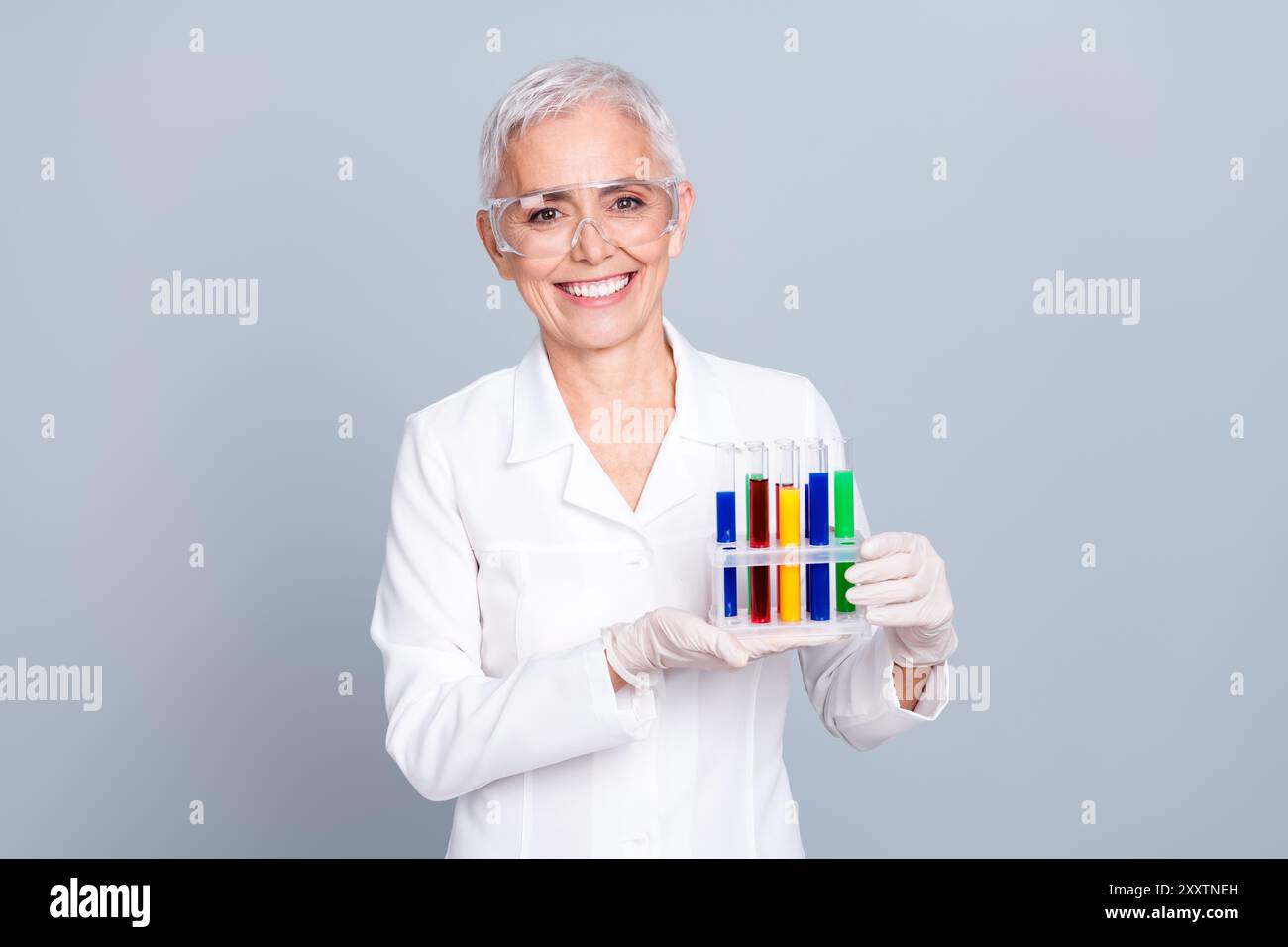 Photo of smiling scientist woman hold many test tube flasks isolated ...