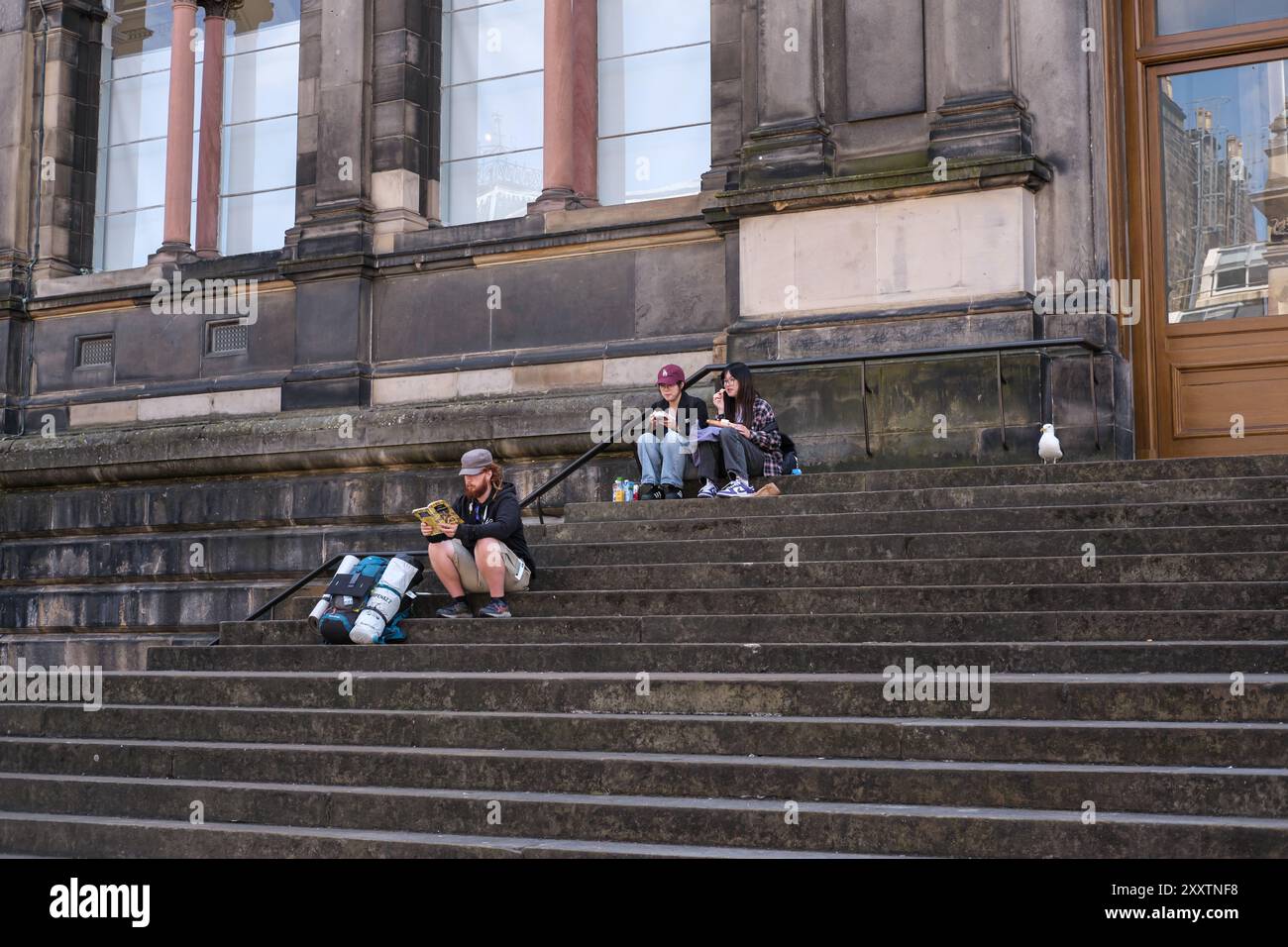 EDINBURGH - JULY 28, 2024: Tourists relax on the steps of the National ...