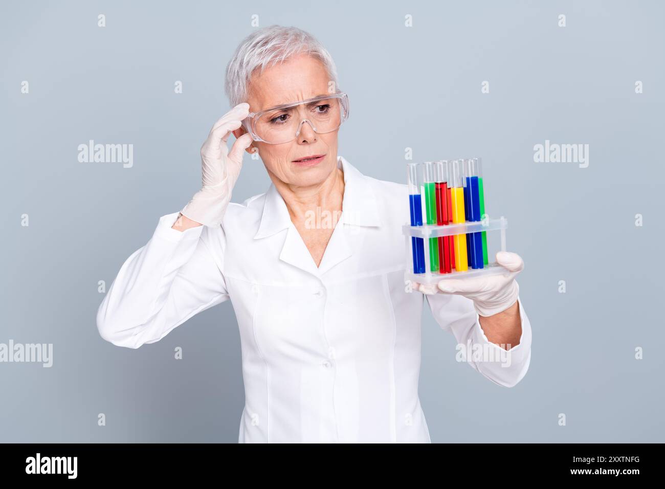 Photo of serious old woman scientist thinking analyze test tube ...