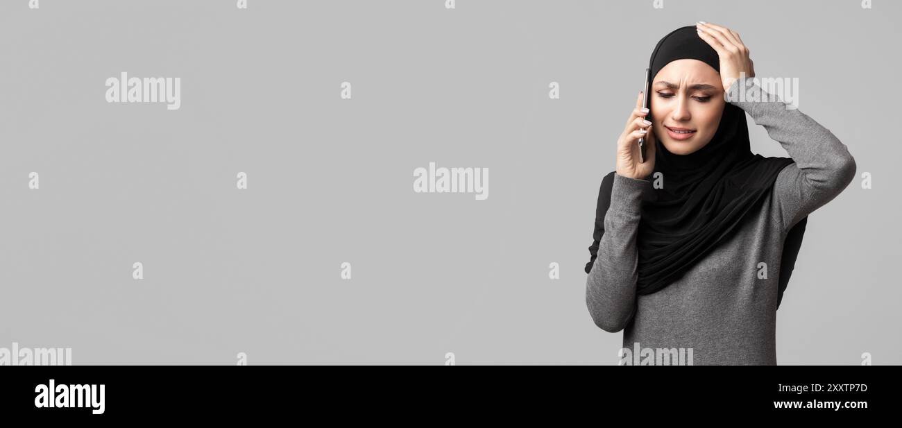 Desperate crying arabic woman in headscarf talking on cellphone ...
