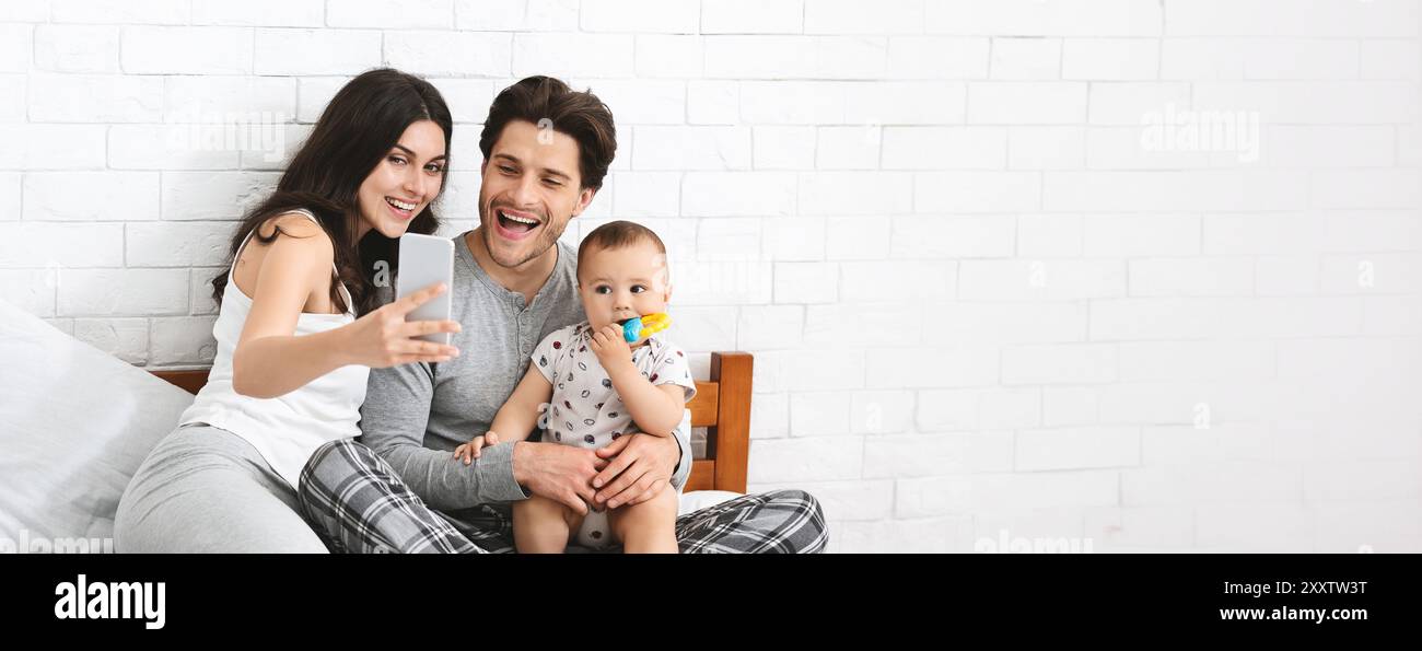 Happy Family Capturing Memories Together While Sitting on a Bed Stock ...