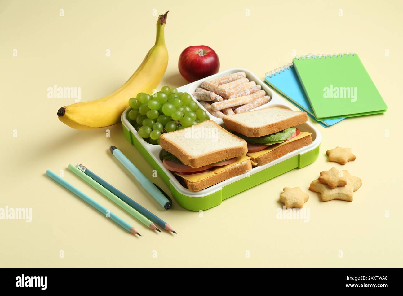 Lunch box with snacks and stationery on yellow table Stock Photo - Alamy