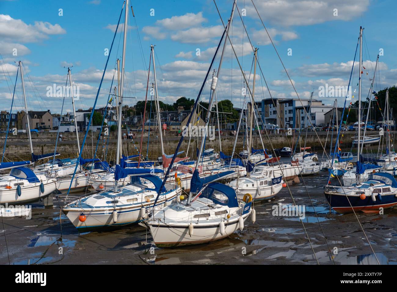 EDINBURGH - JULY 28, 2024: Sailboats are anchored and tilted in the mud ...