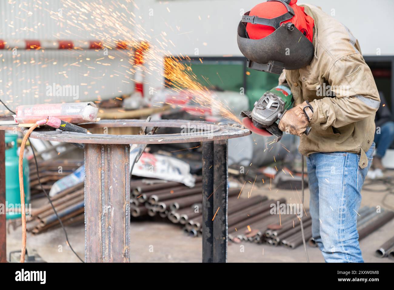 Worker using the grinding tool to smooth out the edges of the iron ...