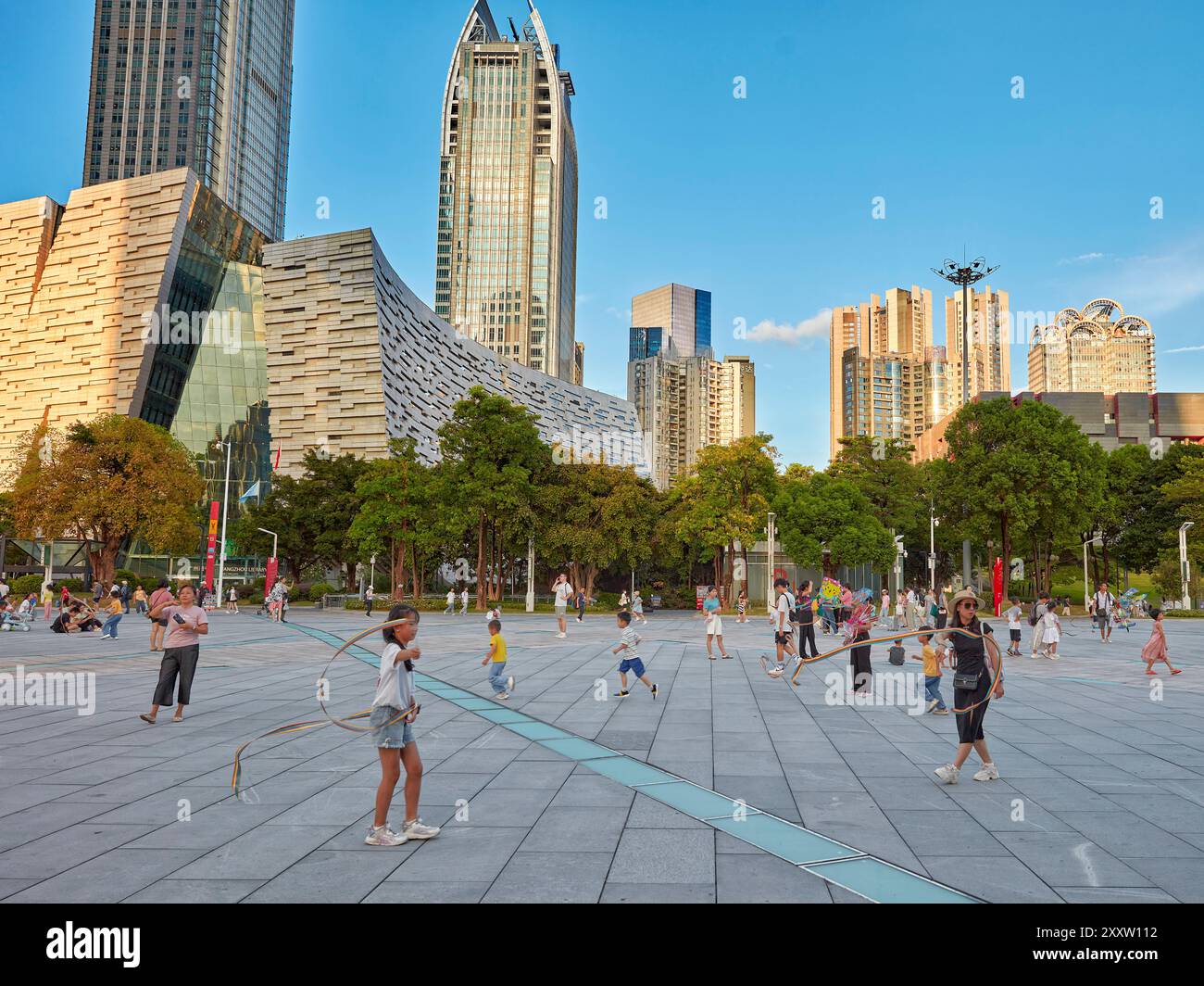 Girls play with ribbons in the Huacheng Square surrounded by modern ...