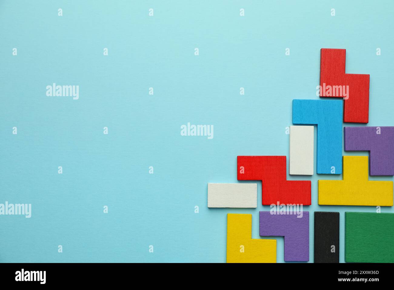 Colorful wooden puzzle pieces on light blue background, top view. Space ...
