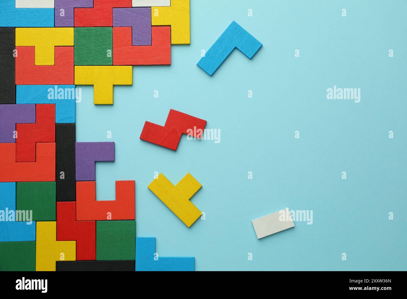 Colorful wooden puzzle pieces on light blue background, top view. Space ...