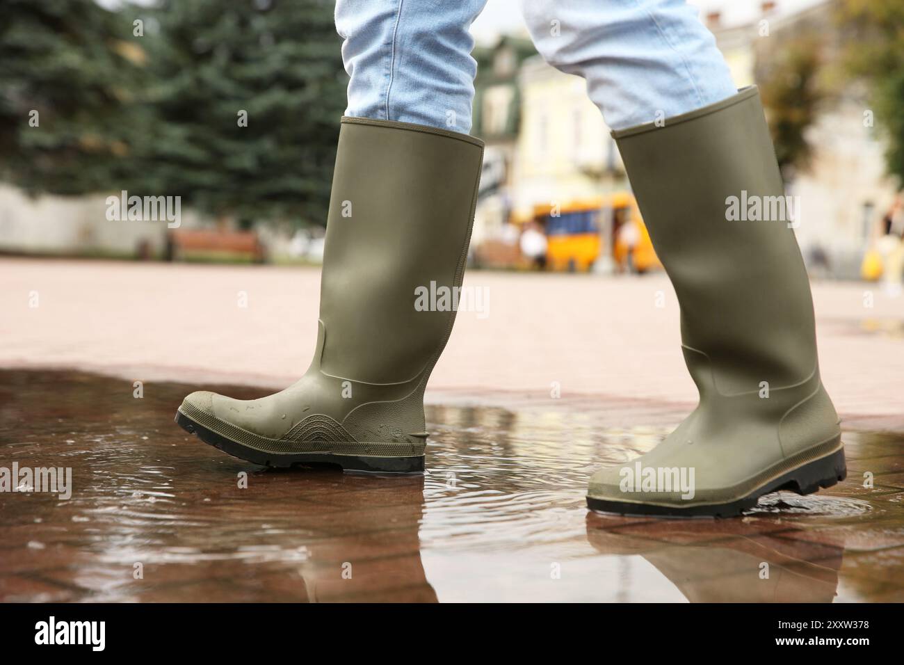 Woman wearing rubber boots walking in puddle outdoors, closeup Stock ...
