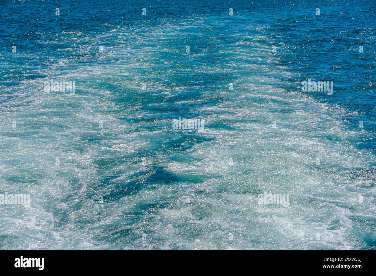 Wake in the ocean created by moving boat, with vibrant blue water and ...