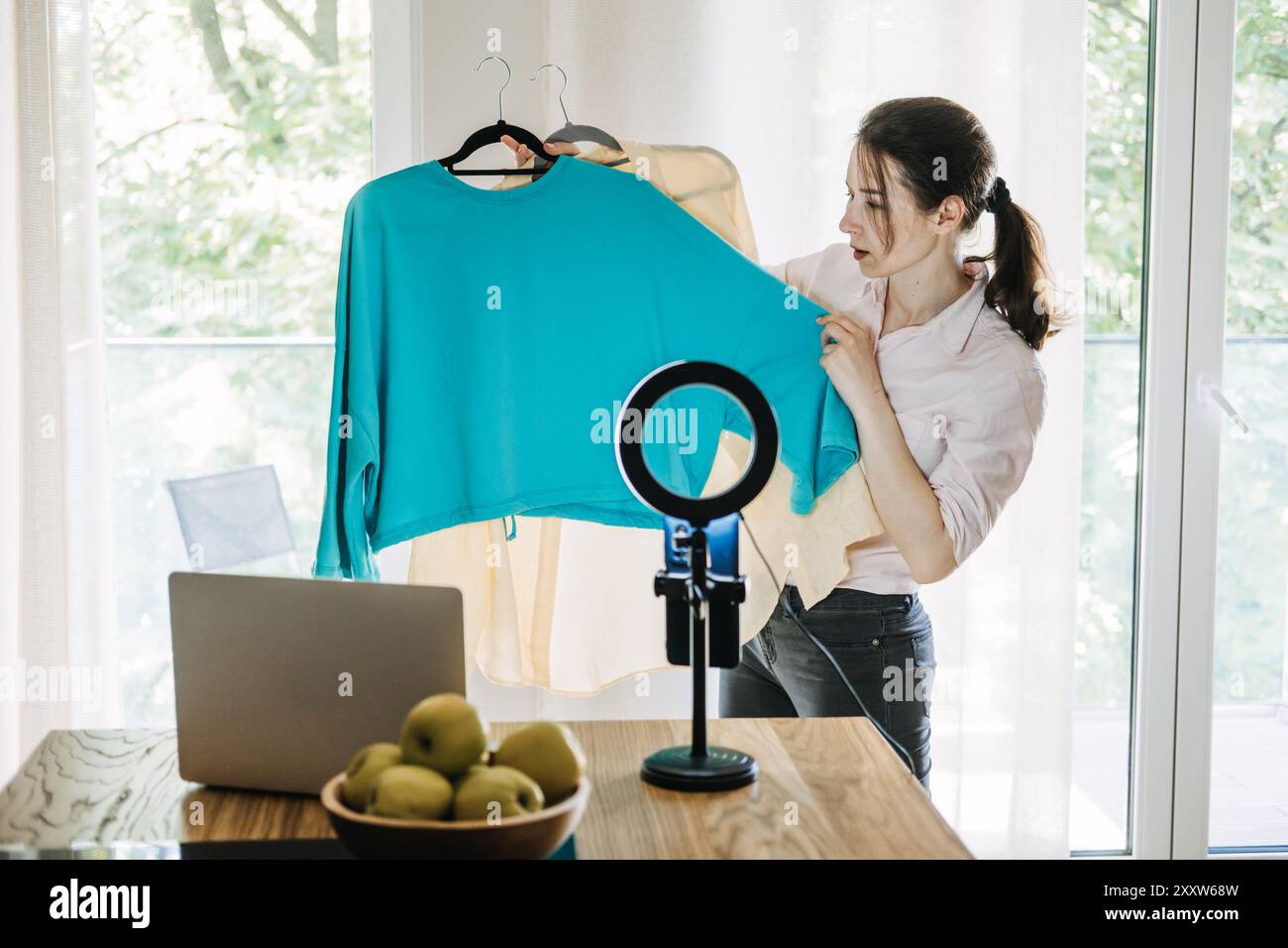 Fashion blogger showcasing outfits during live stream, content creation ...