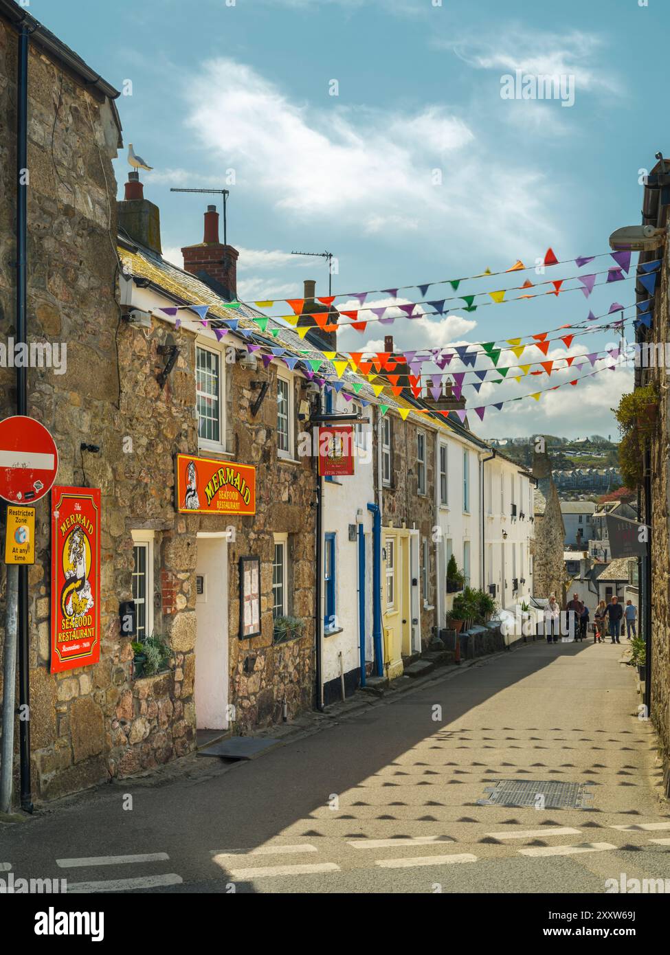 Tourists walk along one of the bunting covered narrow streets in St ...