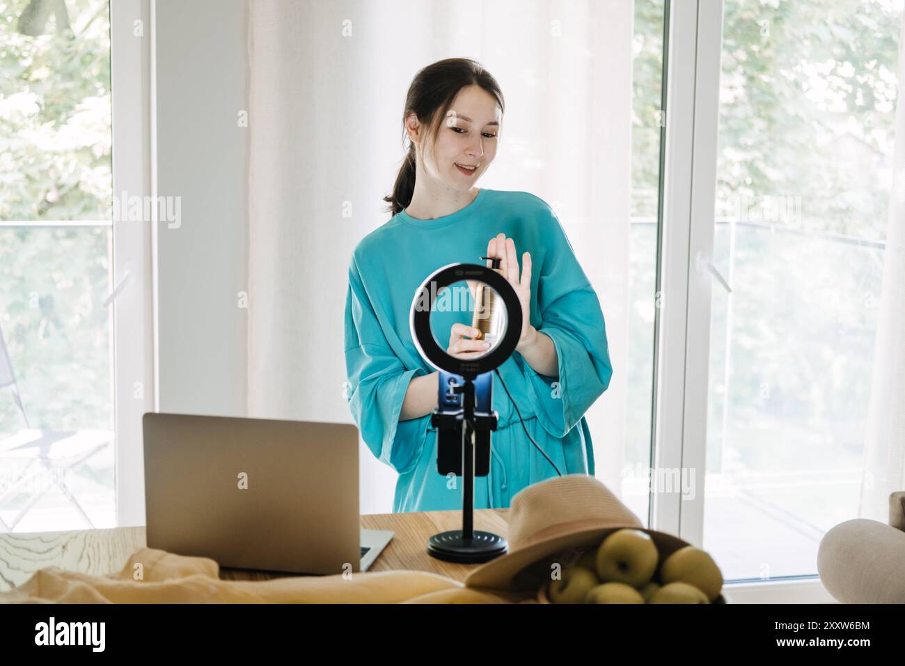 Beauty influencer promoting skincare product with ring light and laptop ...