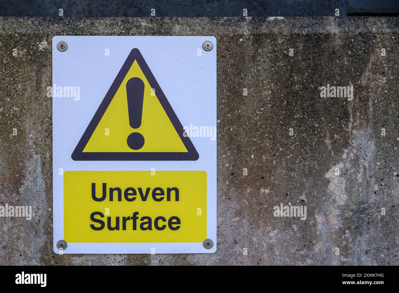 Yellow sign warning of uneven surface Stock Photo - Alamy
